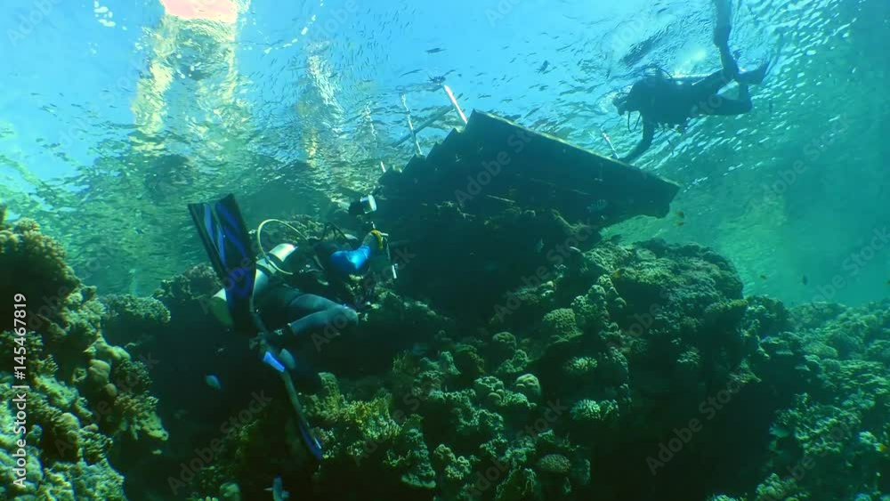Underwater photographer with a camera near the stairs leading to the ...