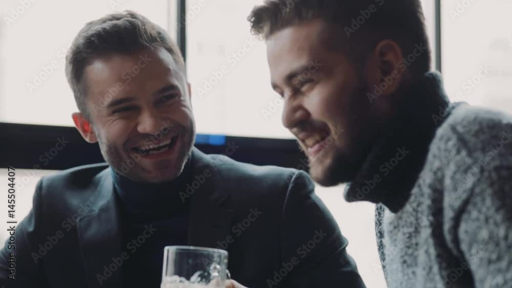 A company of handsome male friends having conversation, they are ...