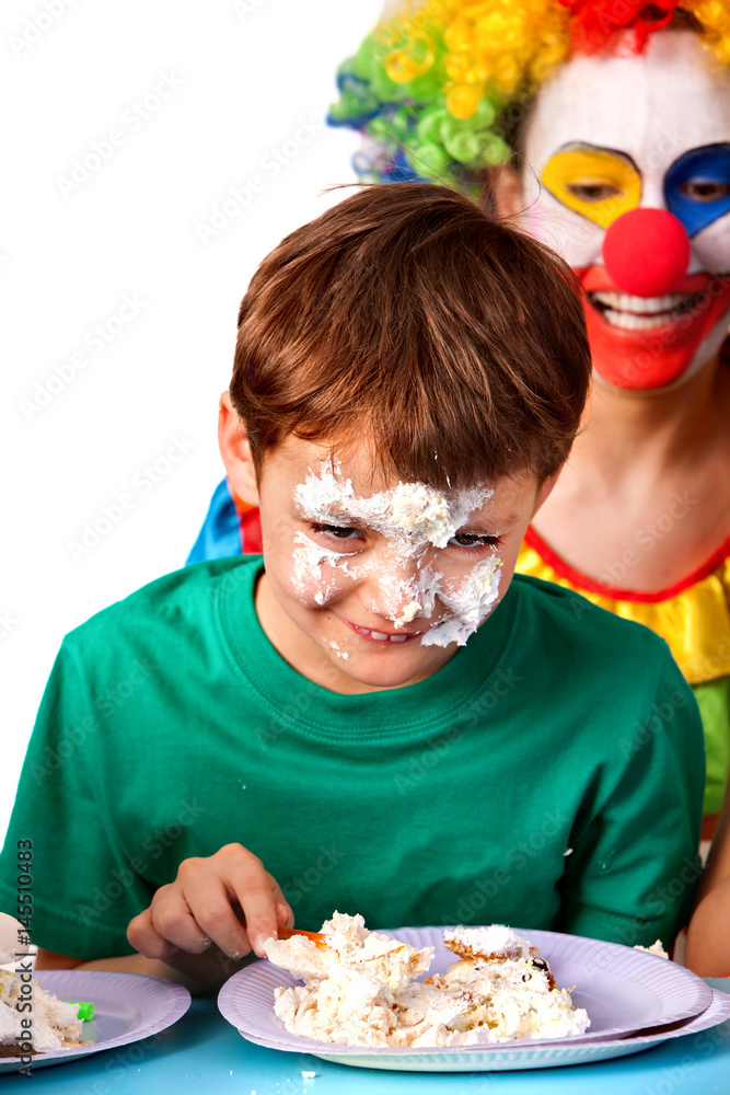 Birthday child clown eating cake with boy together. Kid with messy face ...