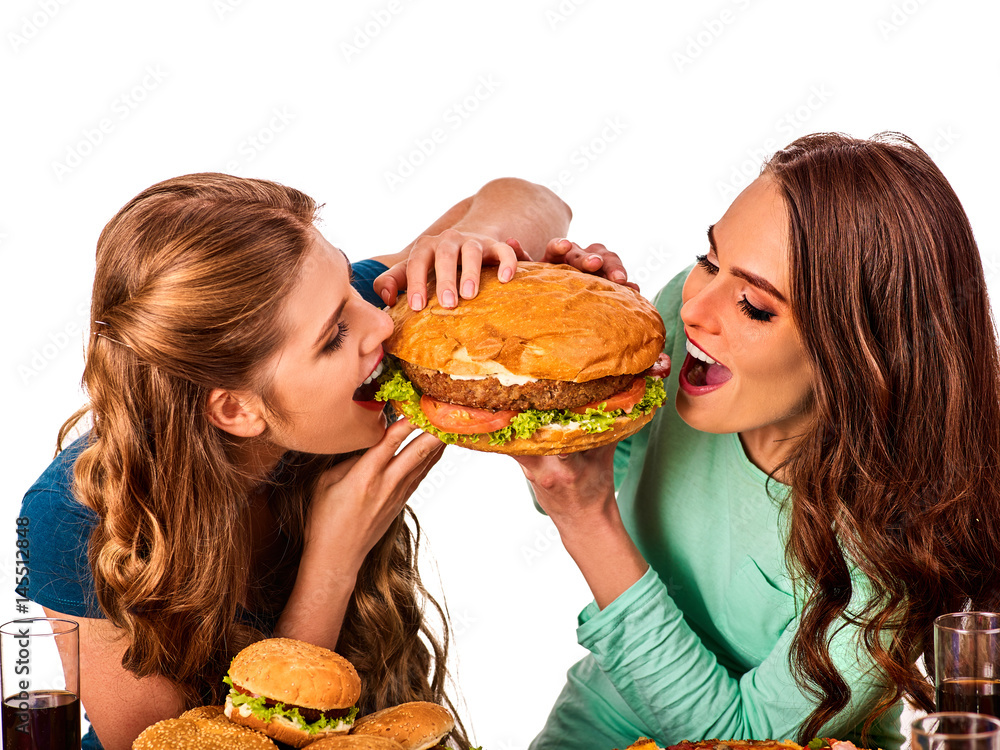 Women eating fast food. Gils eat hamburger with ham . Two friends ...