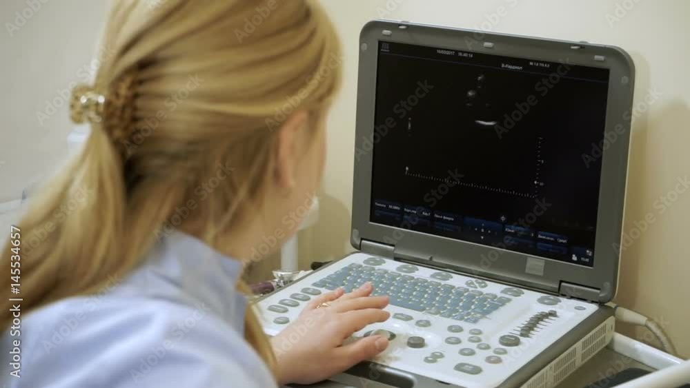 Echocardiography. Female doctor examining a patient's heart by using an ...