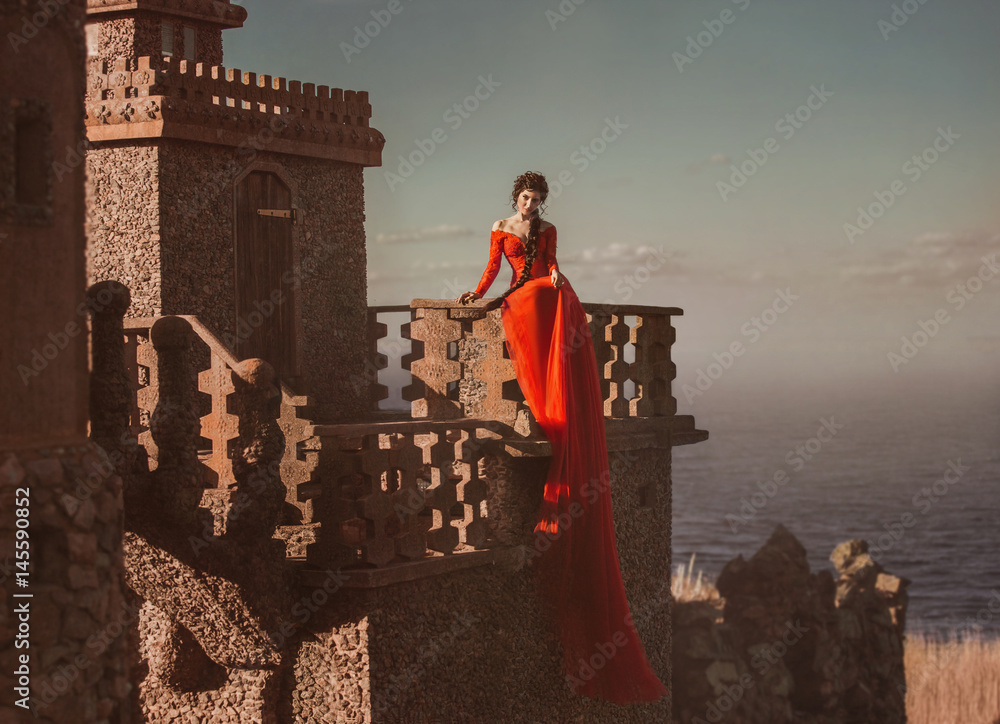 Foto de Beautiful girl sitting on the balcony of the castle. The ...