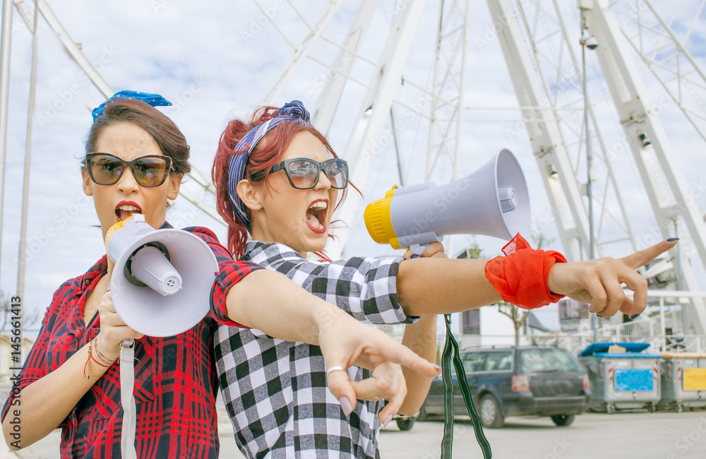 female protesters at rally shouting political slogans with megaphone ...