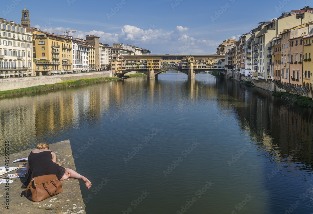 Young blonde female painter leans out of a pylon of the Santa Trinita ...