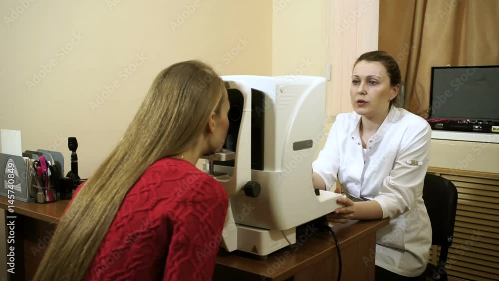 Professional ophthalmologist examining and treating eyes of an young ...