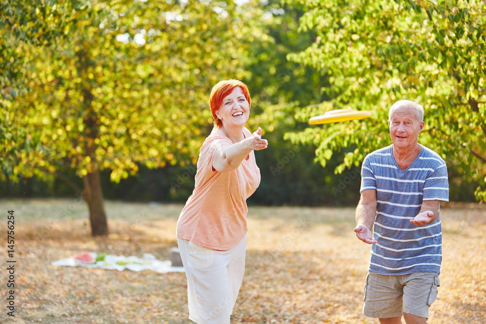 Senior couple playing frisbee and having fun Stock Photo | Adobe Stock