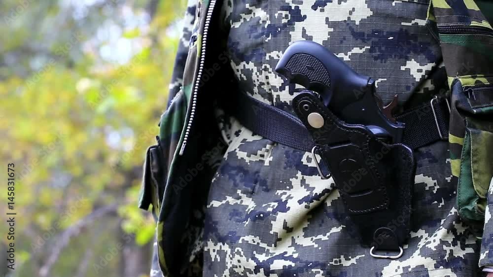 Man in military uniform with revolver in holster. Hunter keeps black ...