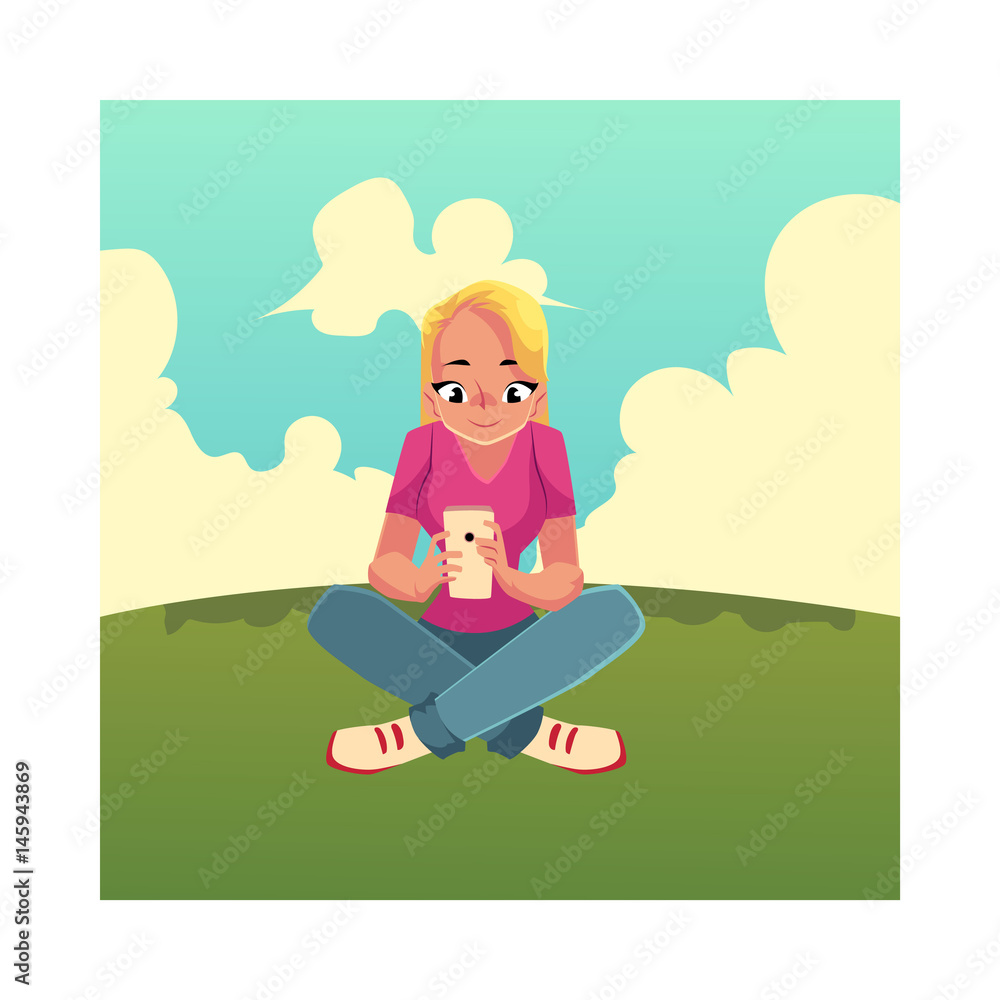 Young woman playing with smartphone on the grass, using mobile phone ...