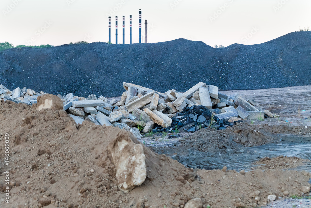 dump of building materials on the background of pipes of the power ...