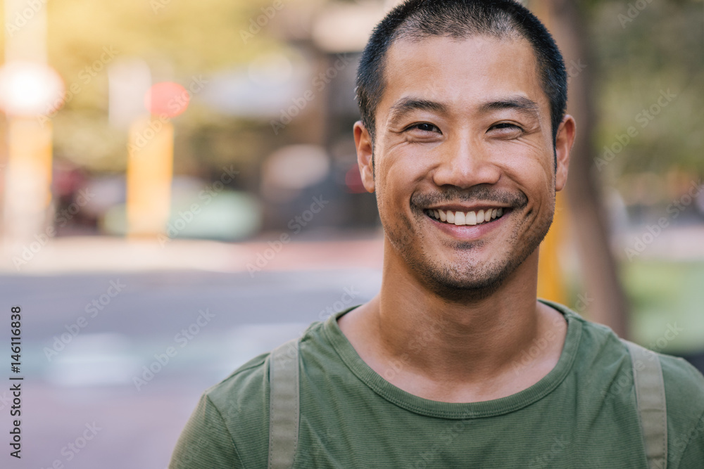 Handsome Asian man standing on a city street and smiling Stock Photo ...