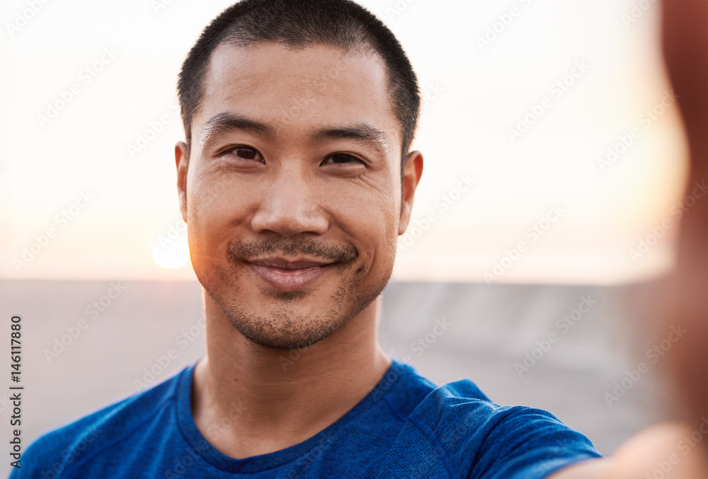 Athletic Asian man smiling while out for a morning run Stock Photo ...