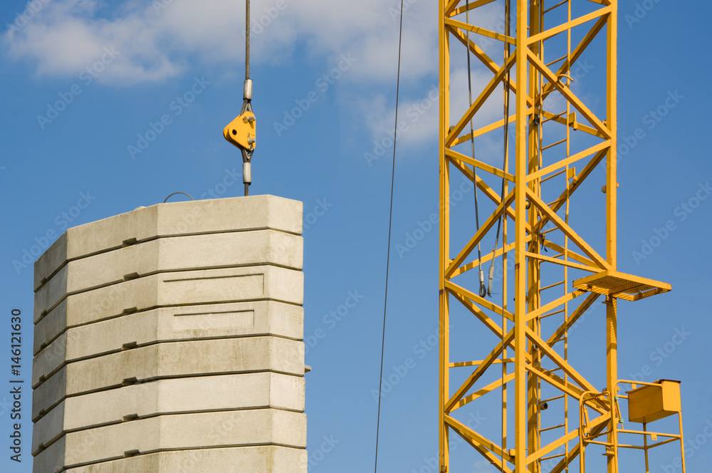 Tower construction crane and concrete blocks against the sky background ...