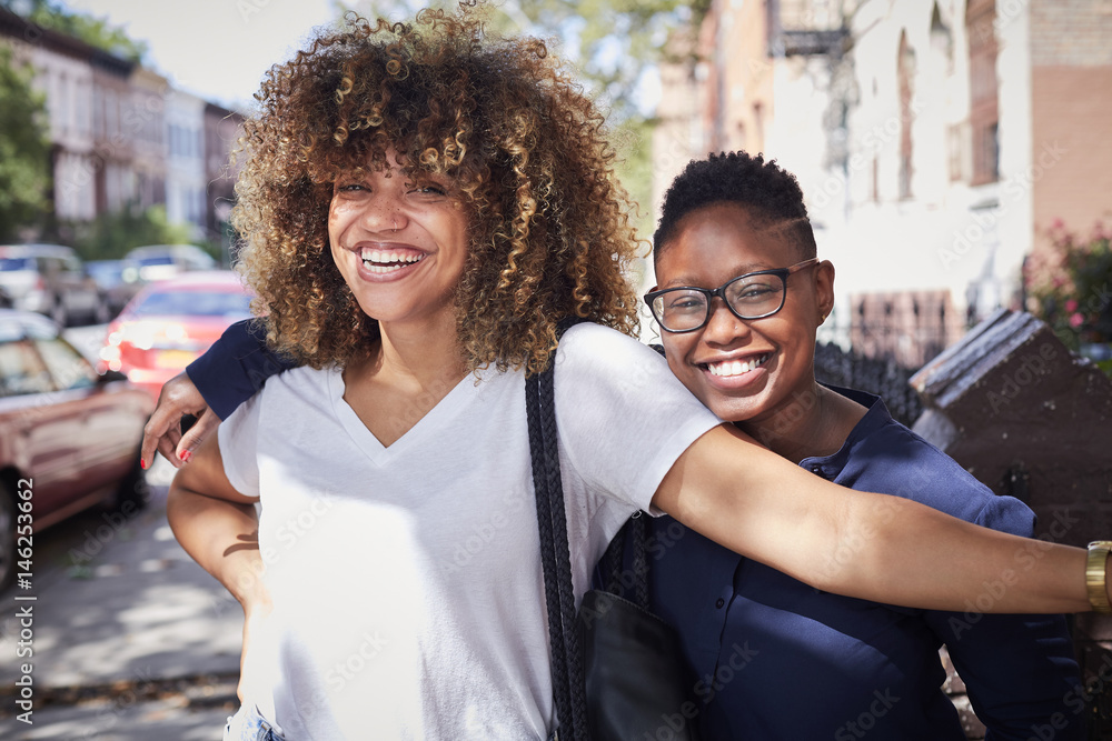 Portrait of Black women hugging on city sidewalk Stock Photo | Adobe Stock