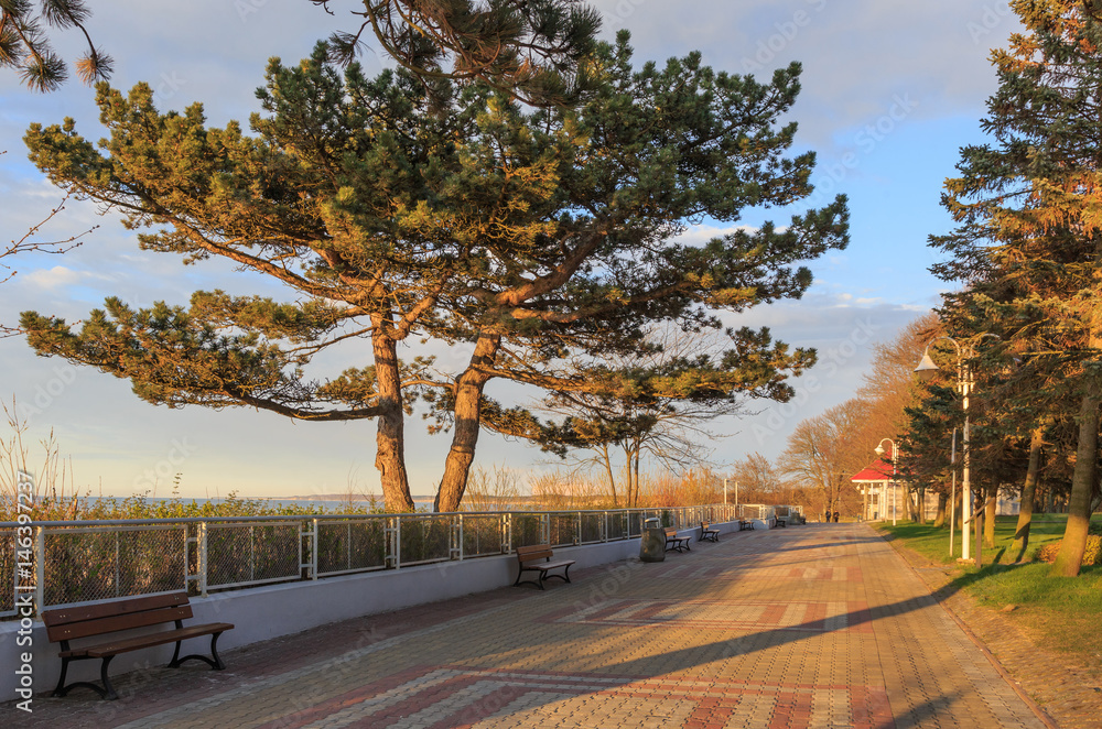 Ustka na polskim pomorzu. Nadmorska promenada oświetlona zachodzącym ...