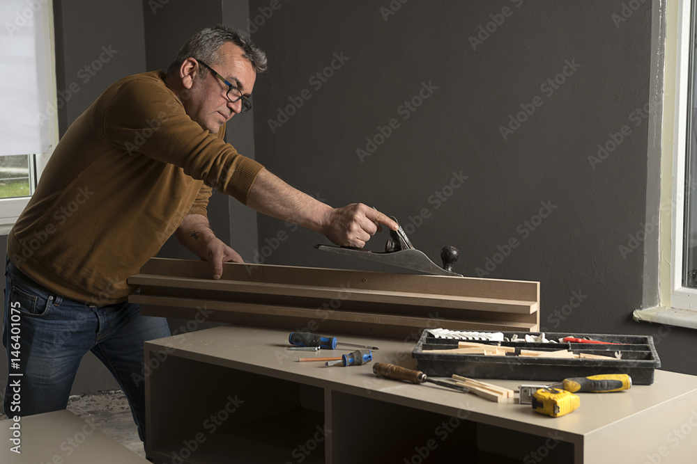 Carpenter planing a plank of wood with a hand plane. Stock Photo ...
