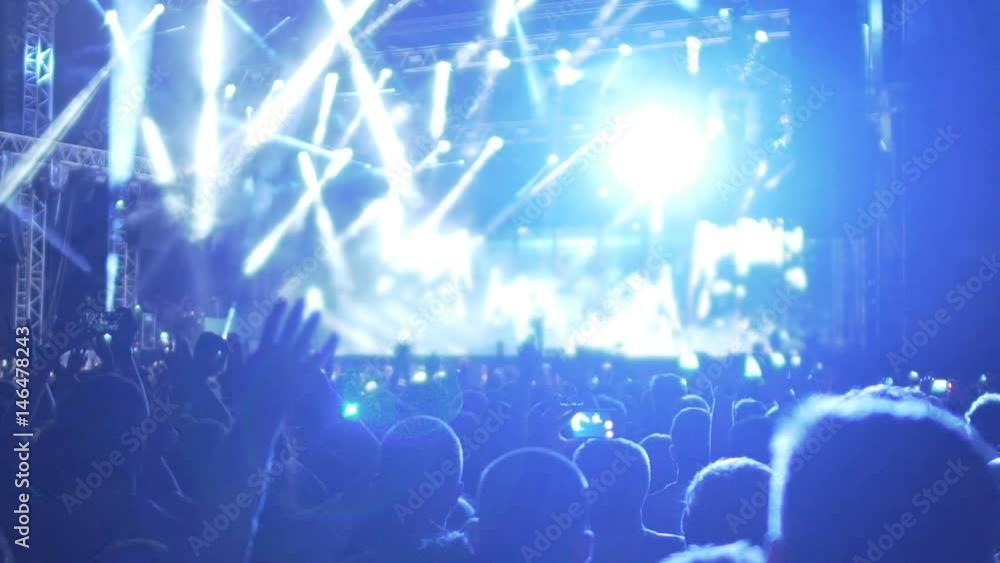 Youth dancing at music concert, jumping and putting hands in the air ...