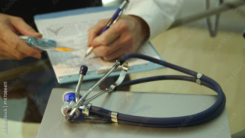doctor writing in patients chart focus on stethoscope Stock Video ...