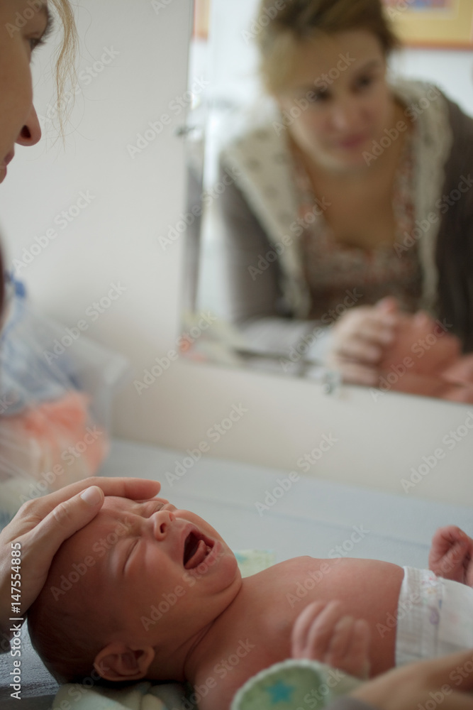 Newborn baby boy crying, mother touching head Stock Photo | Adobe Stock