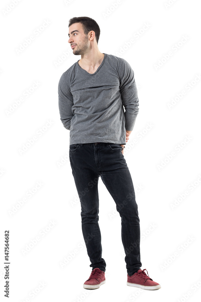 Happy young smiling casual man with hands behind back looking away ... Happy young smiling casual man with hands behind back looking away ...
