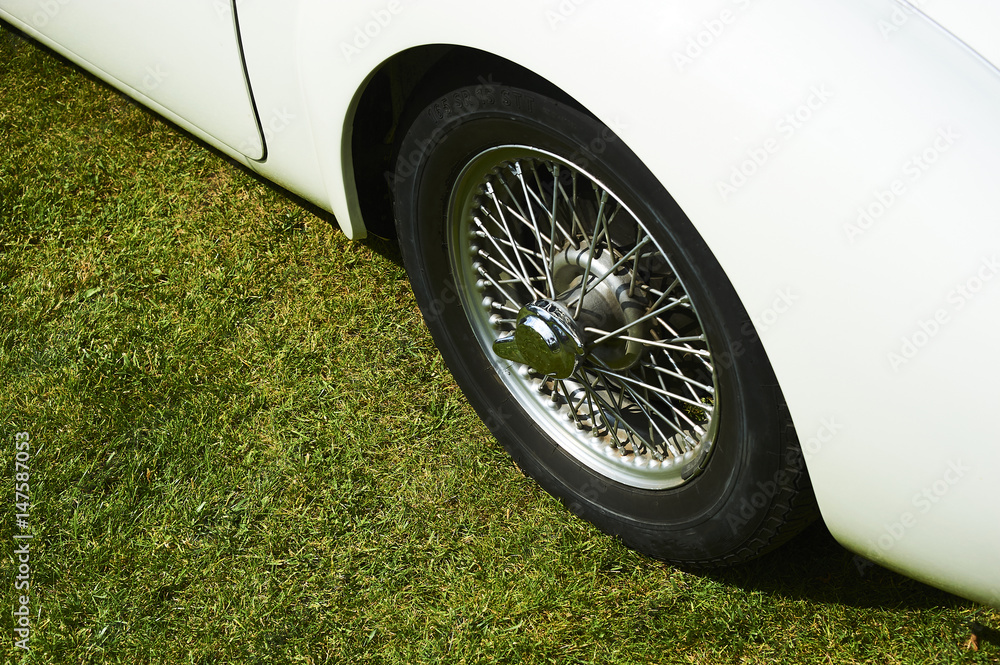 Vintage wheel of classic car on green grass lawn. Beautiful photo of a ...