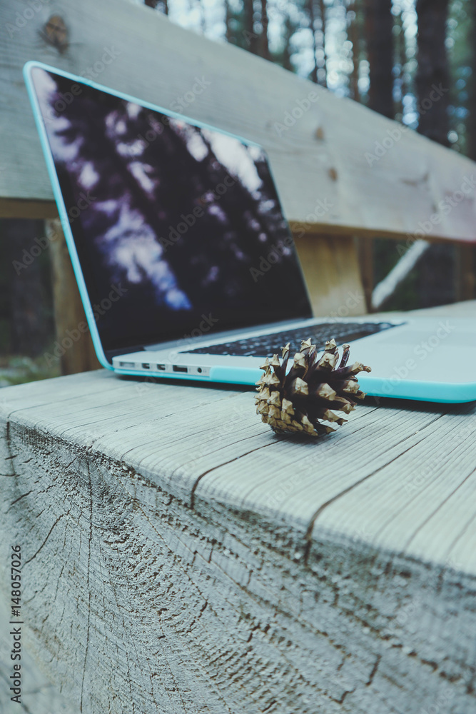 Freelancer laptop computer in the forest on the wooden textured table ...