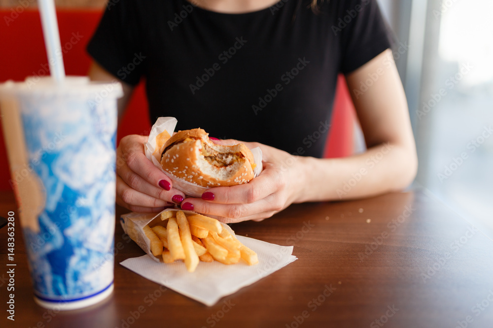 Young girl holding in female hands fast food burger, american unhealthy ...