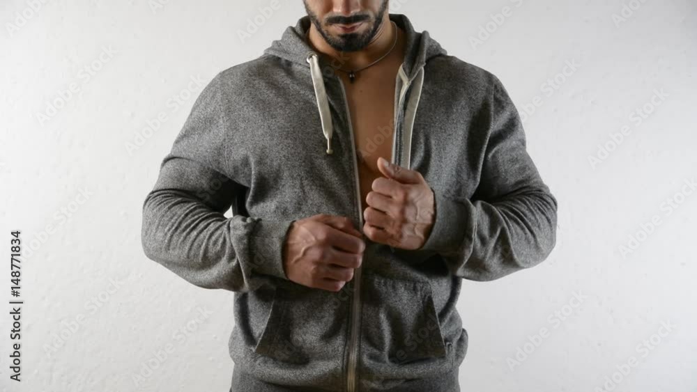 Unrecognizable bodybuilder man undressing, taking off jacket against ...