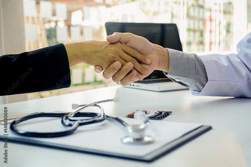 doctor at the clinic giving an handshake to his patient, healthcare and ...