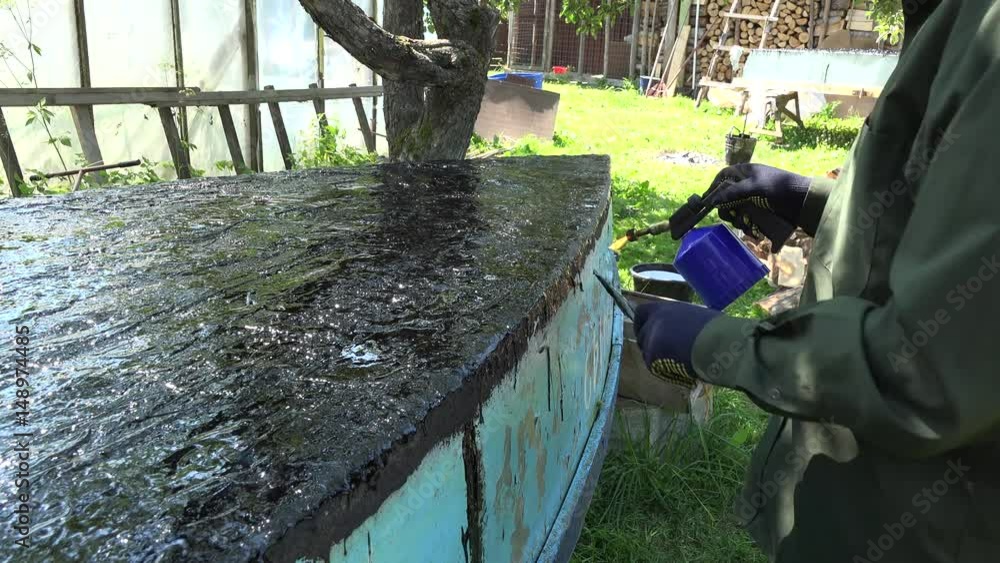 man hands with gas burner torch level tar on boat bottom in big flame ...