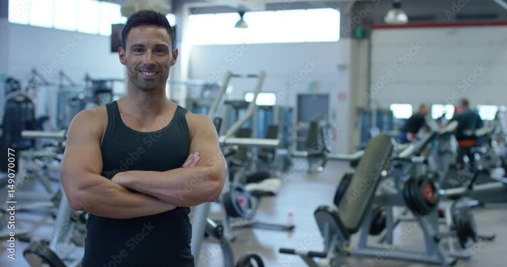 Portrait of a handsome guy in the gym, in good shape and body, smiling ...