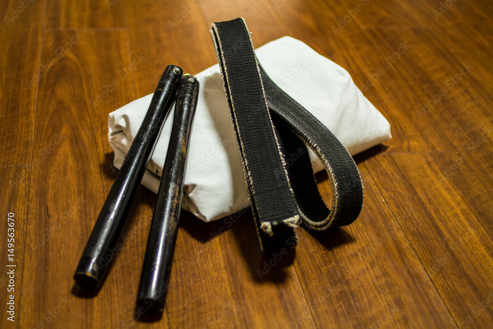 Nunchaku ( traditional okinawan karate's weapon) , black belt and Gi ...