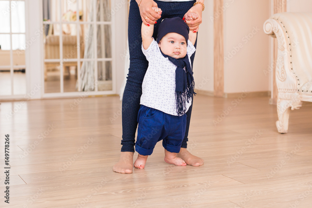 Mom teaching her son's first baby steps indoors Stock Photo | Adobe Stock