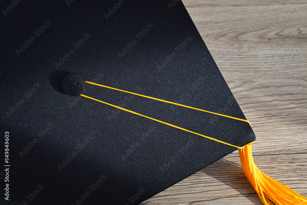 graduation cap with Yellow tassel on wood table background Stock Photo ...