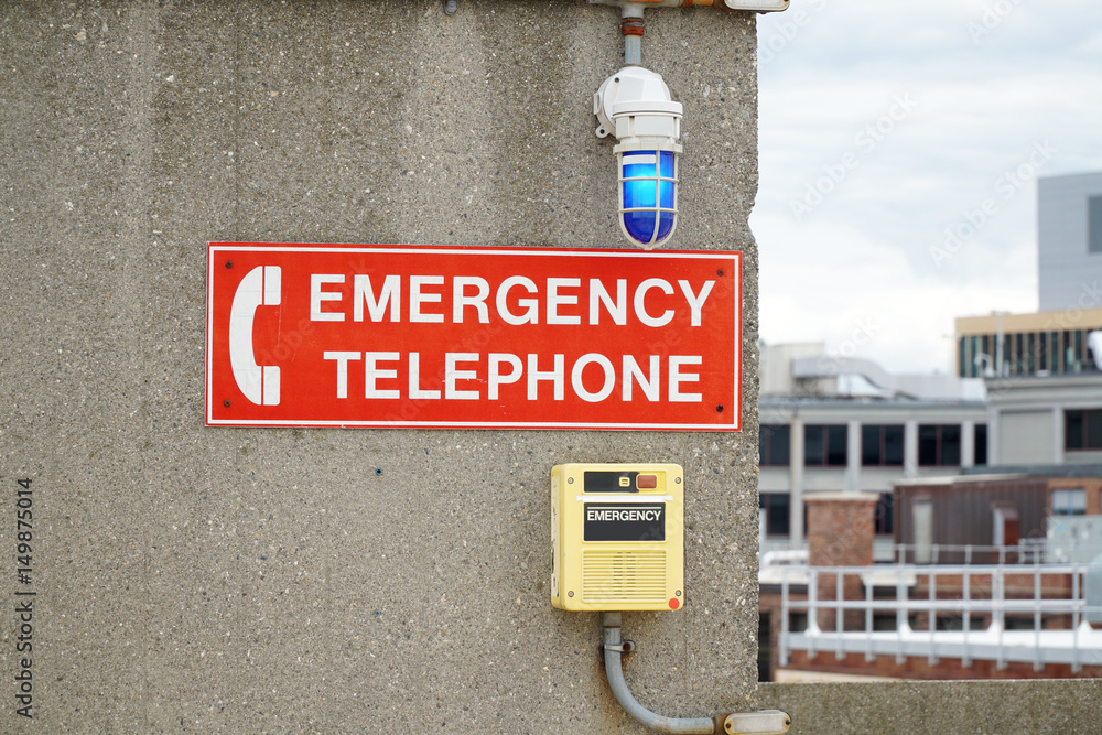 emergency telephone and warning sign in the wall of parking lot Stock ...