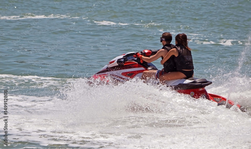 Teen aged boy and girl riding tandem on a seeding jet ski Stock Photo ...