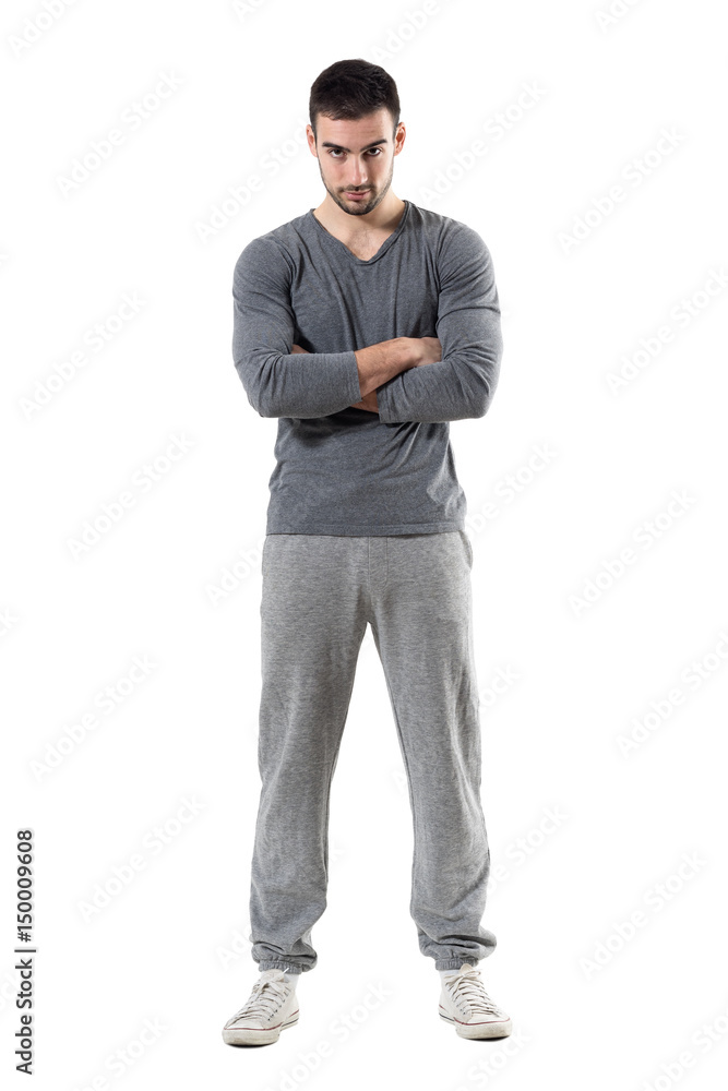 Tough young serious athletic sporty man staring at camera with crossed ...