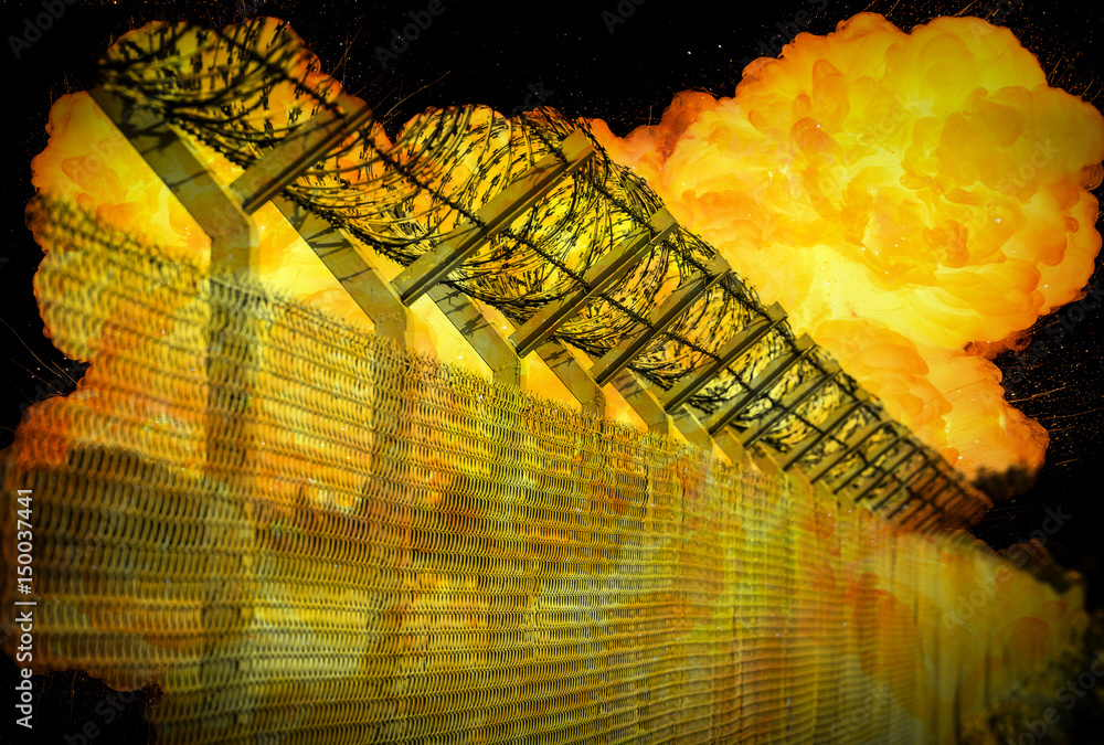 Realistic orange fire explosion behind restricted area barbed wire ...