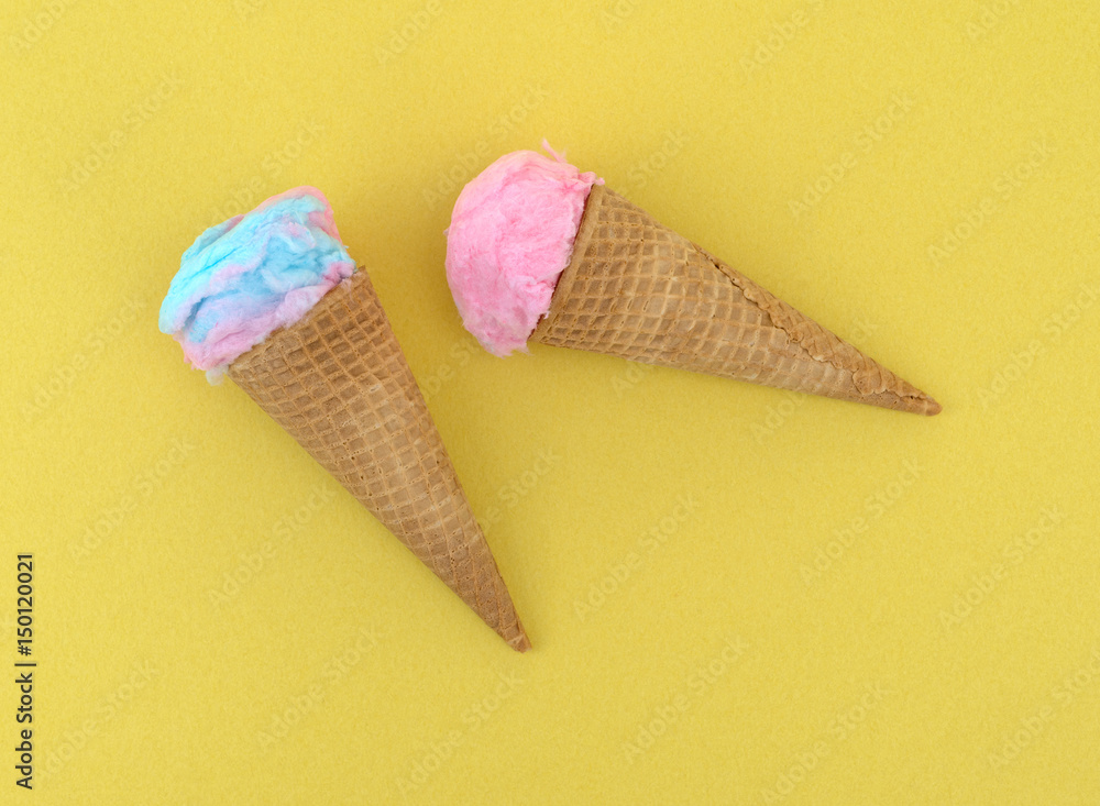 Pink and blue cotton candy shaped like ice cream in sugar cones atop a ...