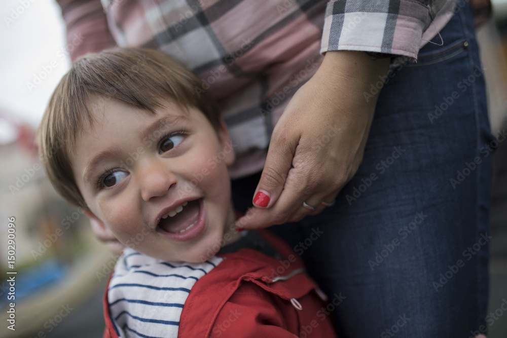 Happy child between her mother's legs Photos | Adobe Stock
