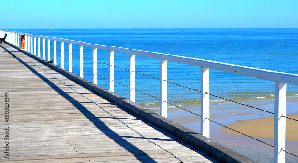 Sunny beach scene from jetty point of view. Stock Photo | Adobe Stock