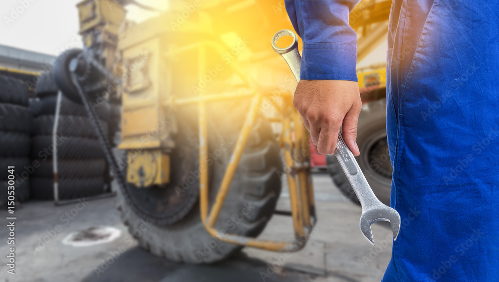 The mechanic with the arms of the cross with a large crane wheel at ...