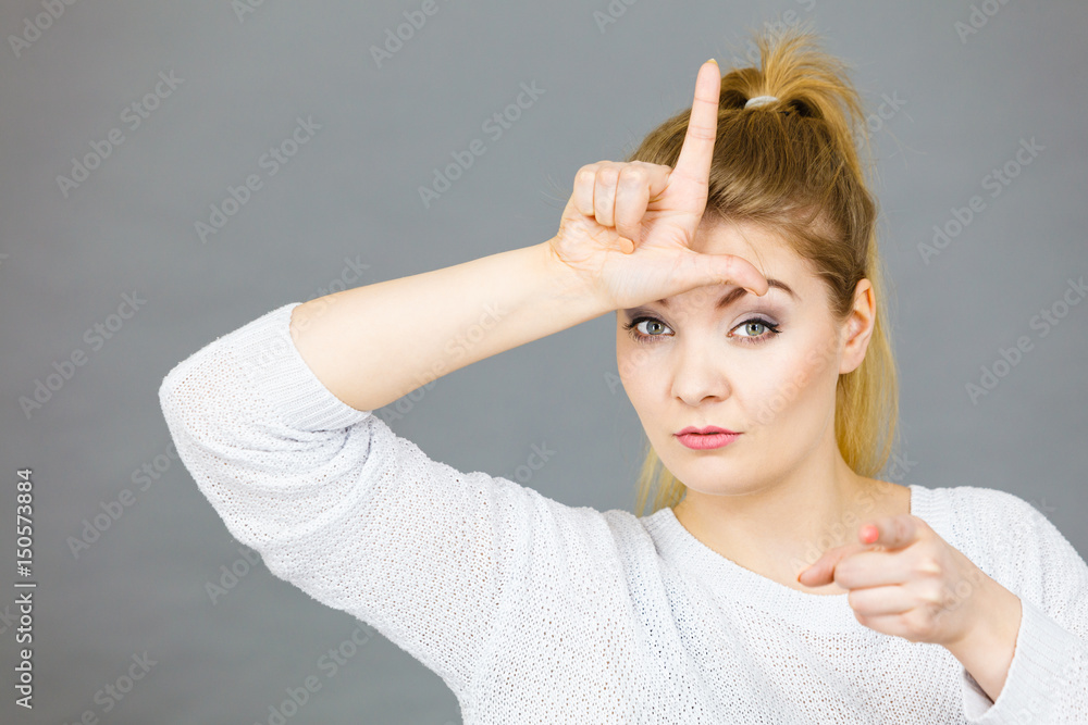 Woman showing loser gesture with L on forehead Stock Photo | Adobe Stock