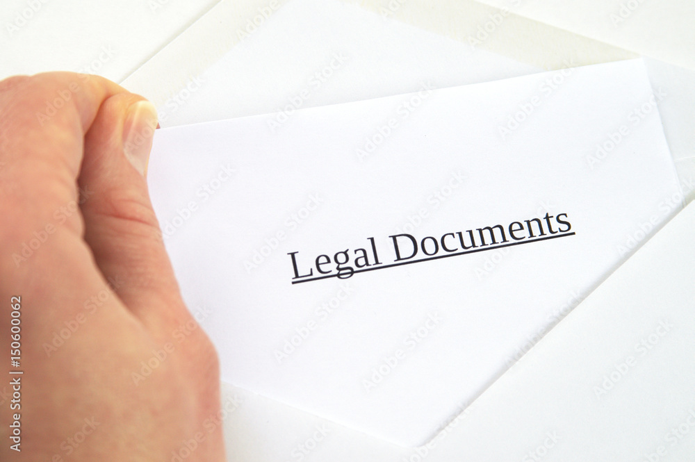 Legal Documents printed on white paper and envelope, hand holding it ...