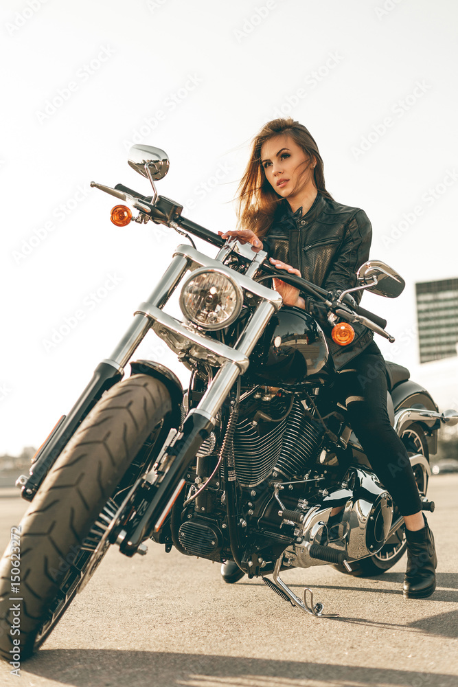 Girl on a motorcycle. She is beautiful, posing on a motorcycle at ...