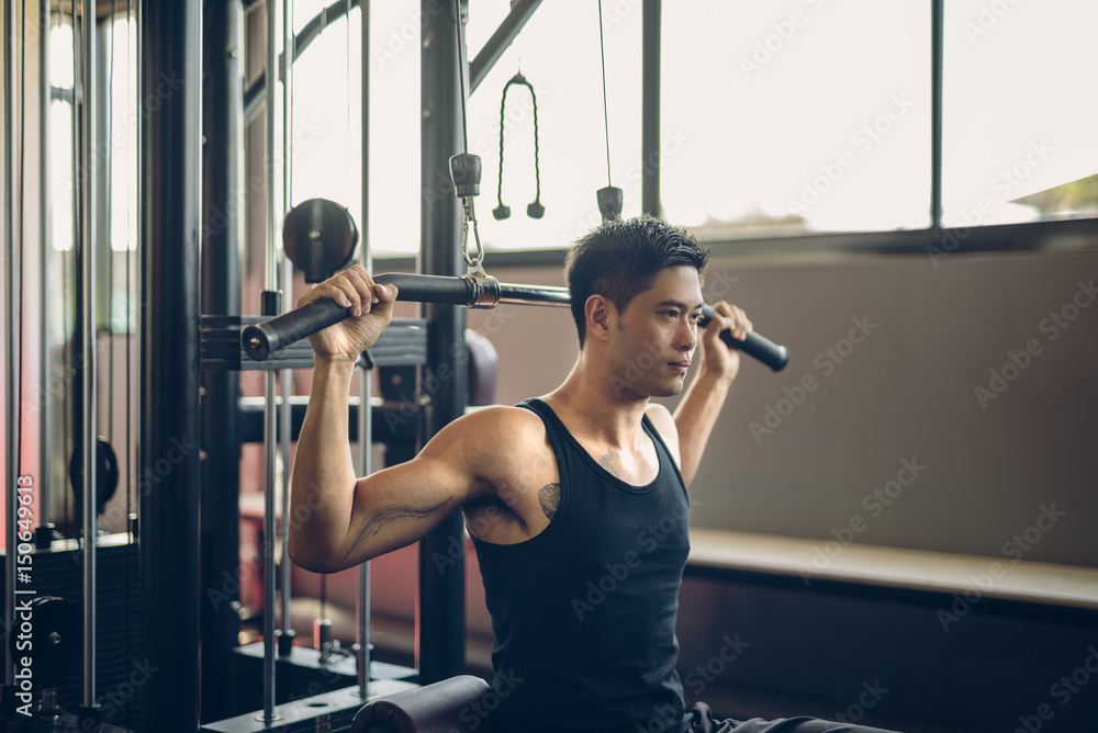 Asia Man with muscle in lat pull-down gym machine. Stock Photo | Adobe ...