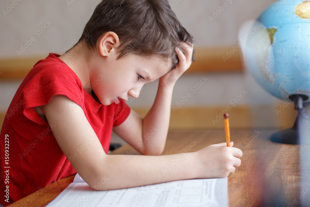 Sad little boy depressed while doing homework Stock Photo | Adobe Stock
