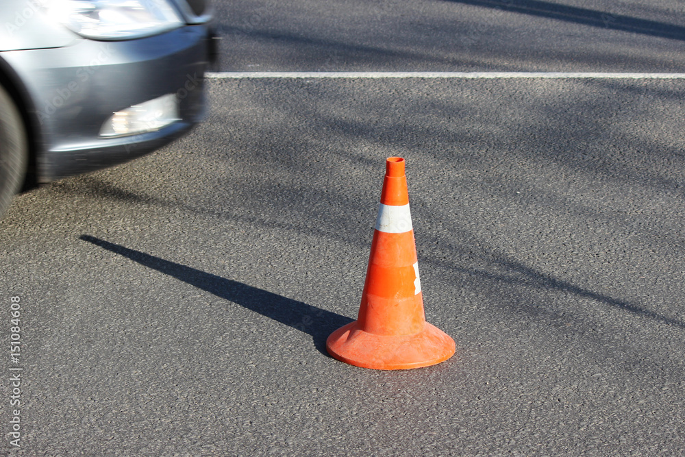 plastic signaling traffic cone encloses a place in the parking lot for ...