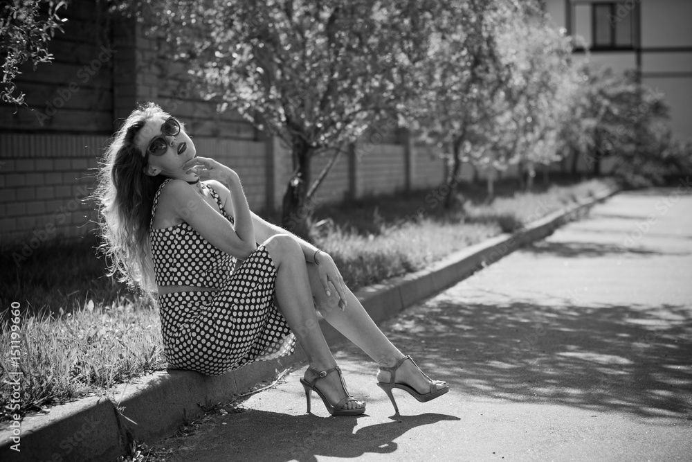 A playful American sweet and sexy girl in a pin up suit with polka dots with red lips adr ...
