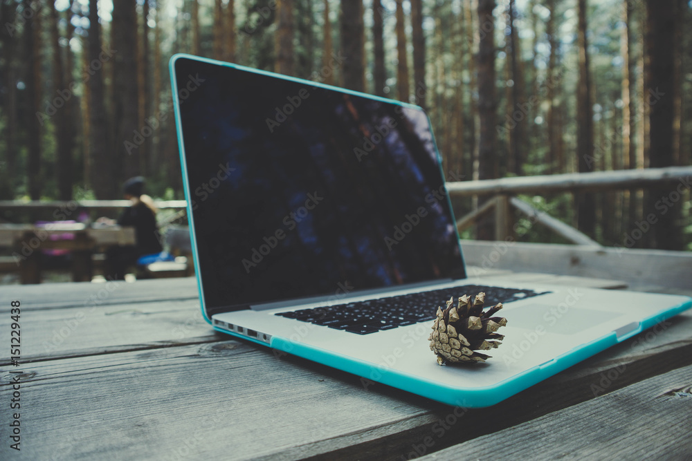 Freelancer laptop computer in the forest on the wooden textured table ...