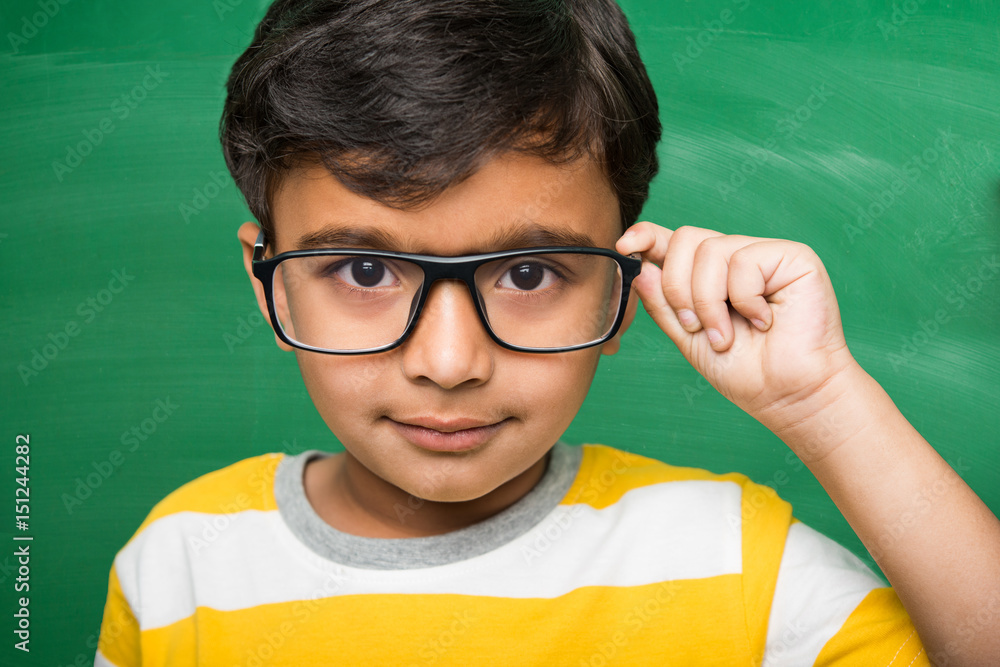 indian school kid or boy in spectacles in thinking pose, standing ...